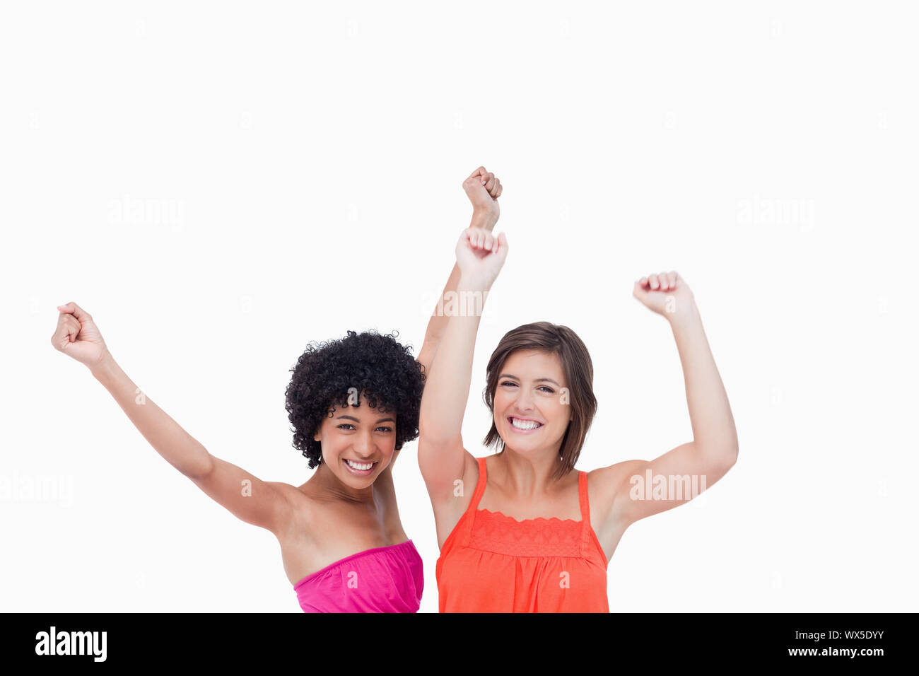 Happy teenagers raising their arms above their head against a white ...