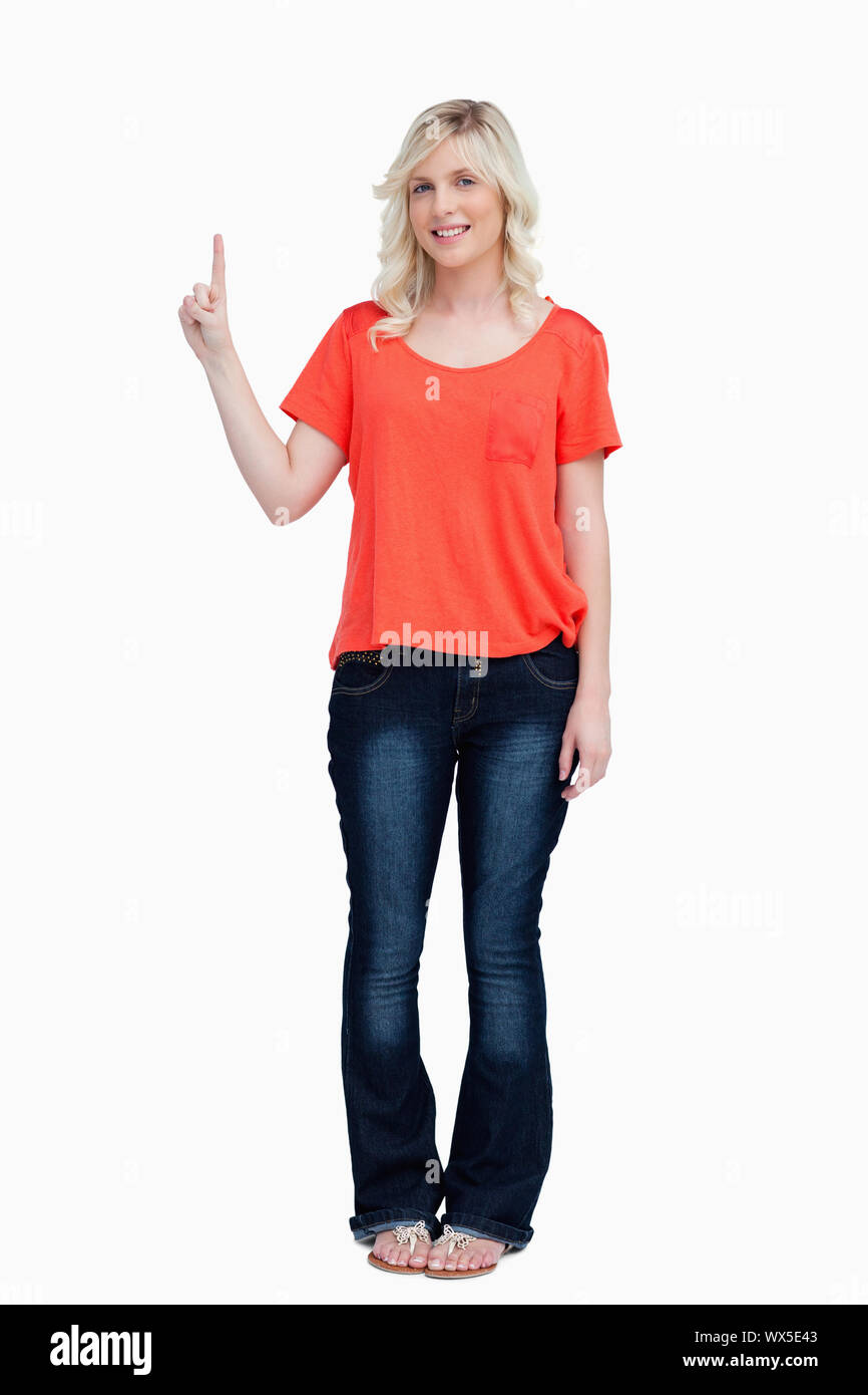 Smiling teenager raising her finger in the air against a white ...