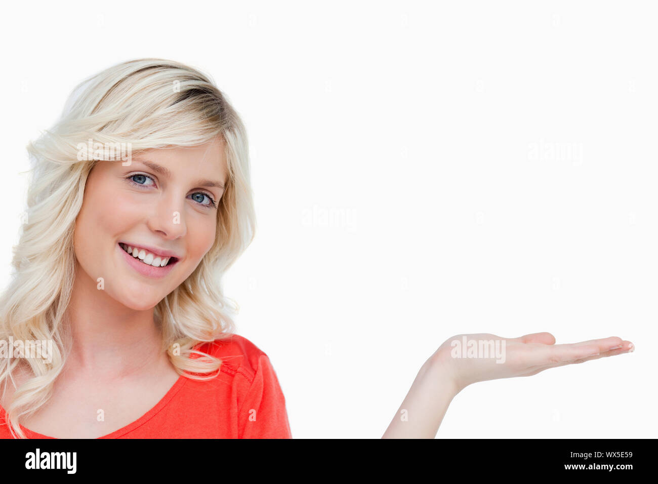 Woman putting her hand palm up while showing a great smile Stock Photo ...