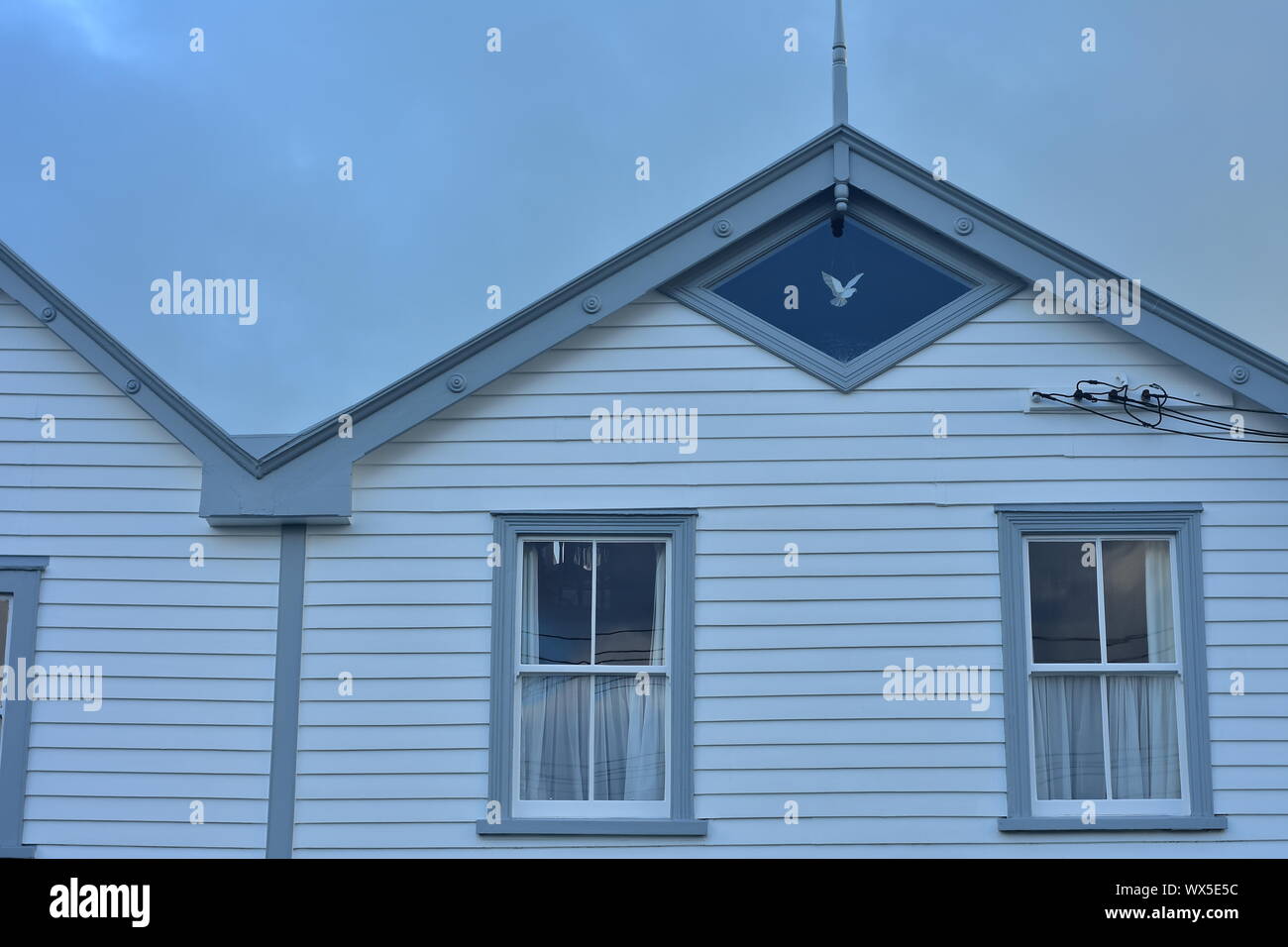 Facade detail of vintage wooden house with rectangular windows and one ...