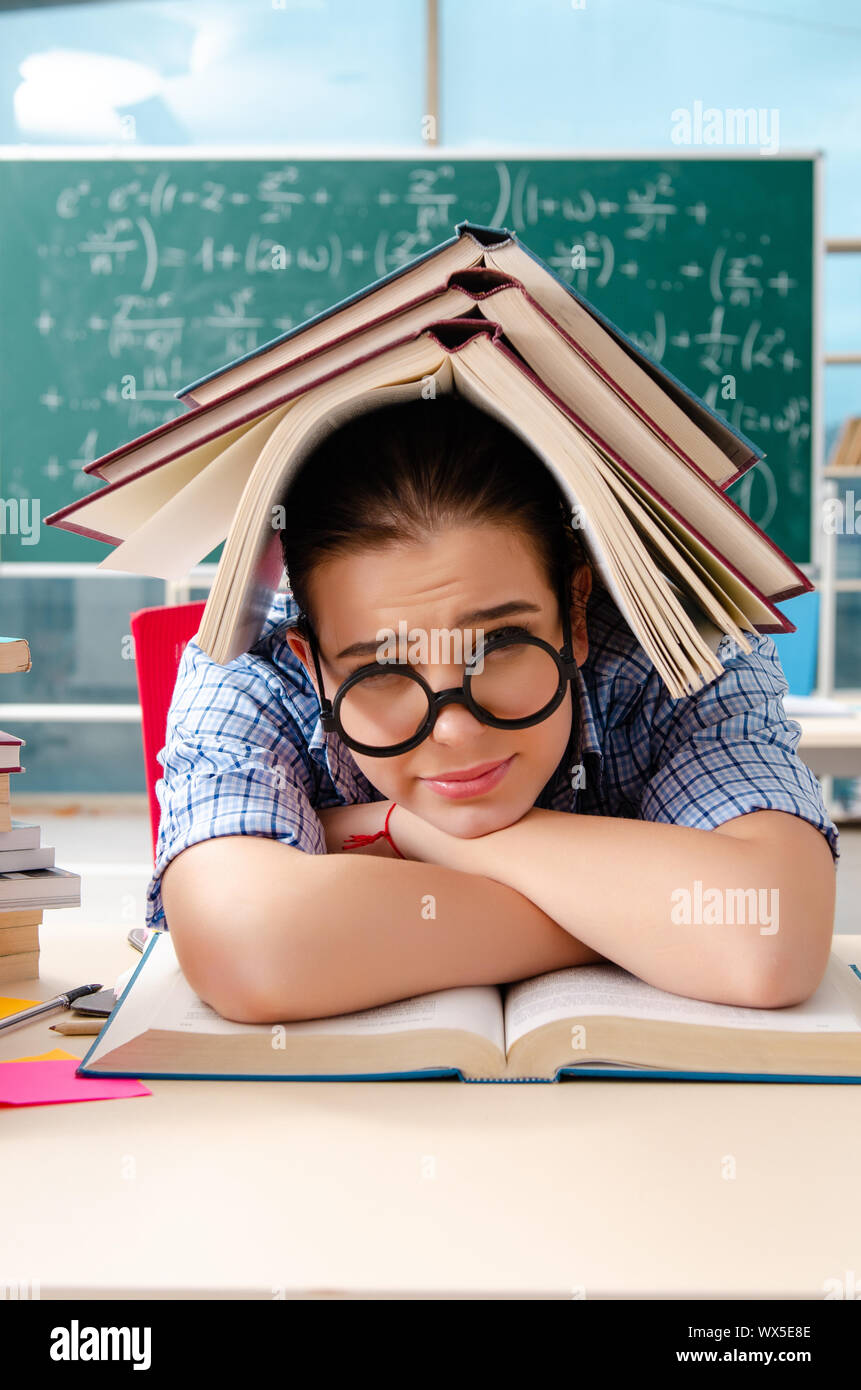 Female student with many books sitting in the classroom Stock Photo - Alamy