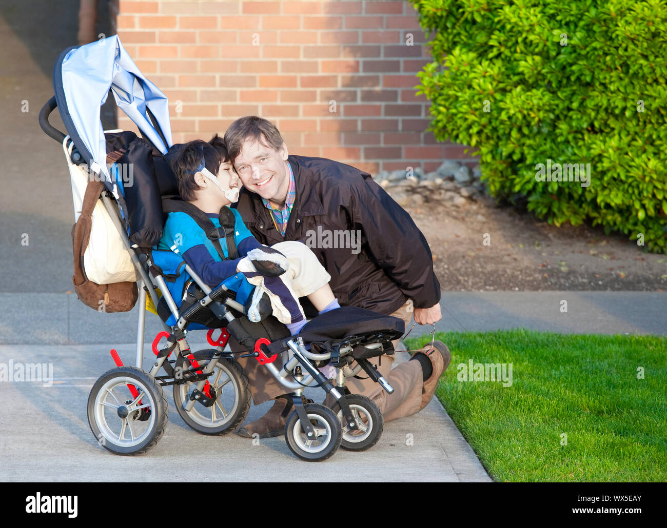 Disabled boy in wheelchair and his father Stock Photo - Alamy