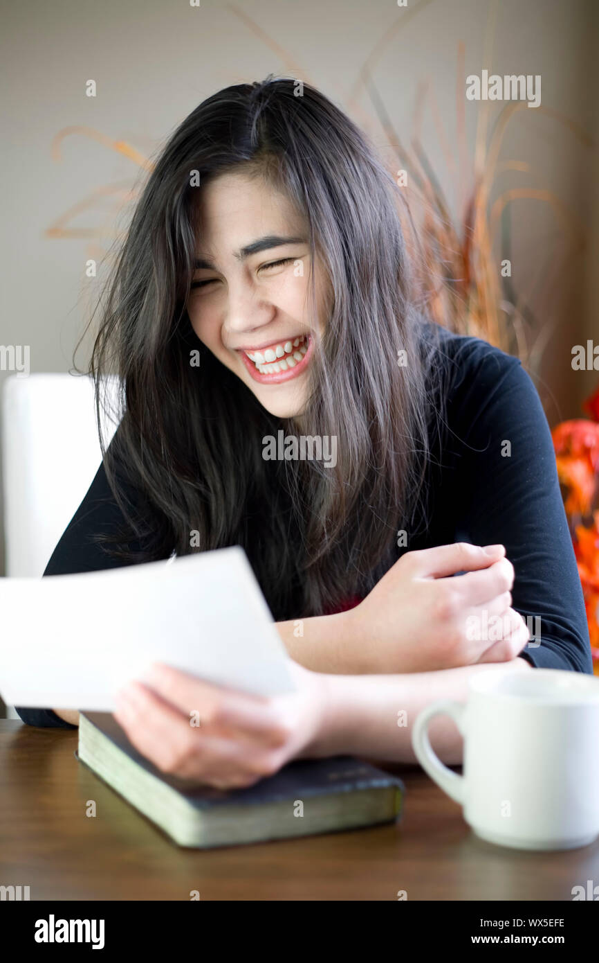 Teenage girl or young woman happily reading note in hand Stock Photo ...