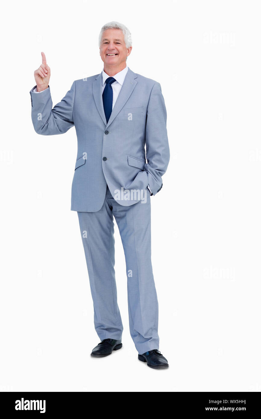 Portrait of a happy businessman pointing up against white background ...