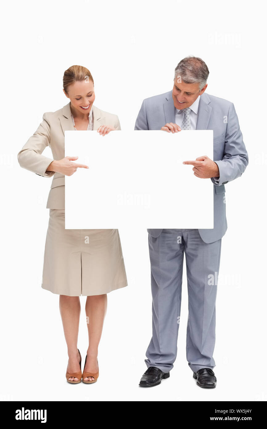 Smiling business people holding a poster against white background Stock ...