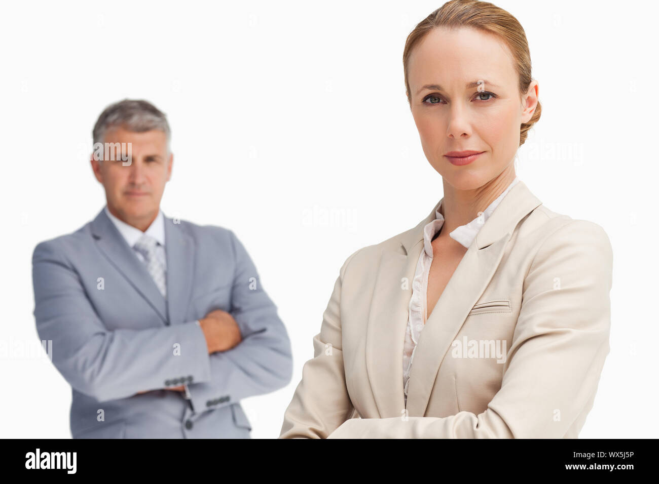 Serious business people with folded arms against white background Stock Photo - Alamy