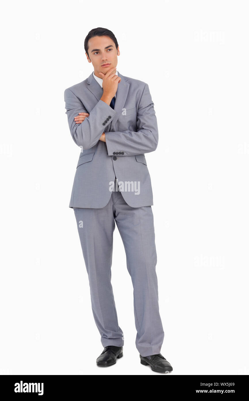 Thoughtful businessman with folded arms against white background Stock Photo - Alamy