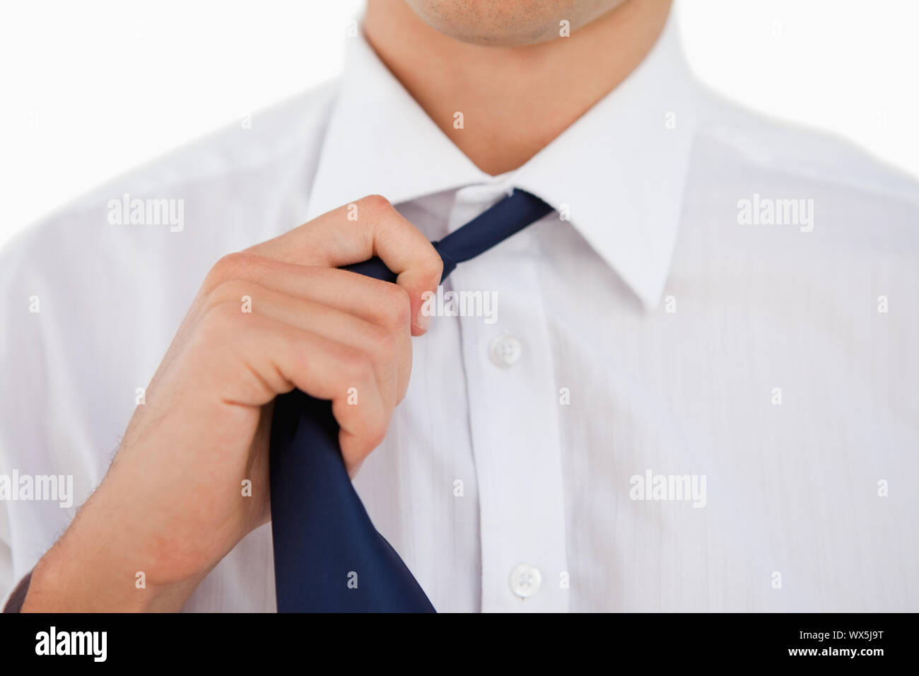 Close-up of a man undoing his tie against white background Stock Photo ...