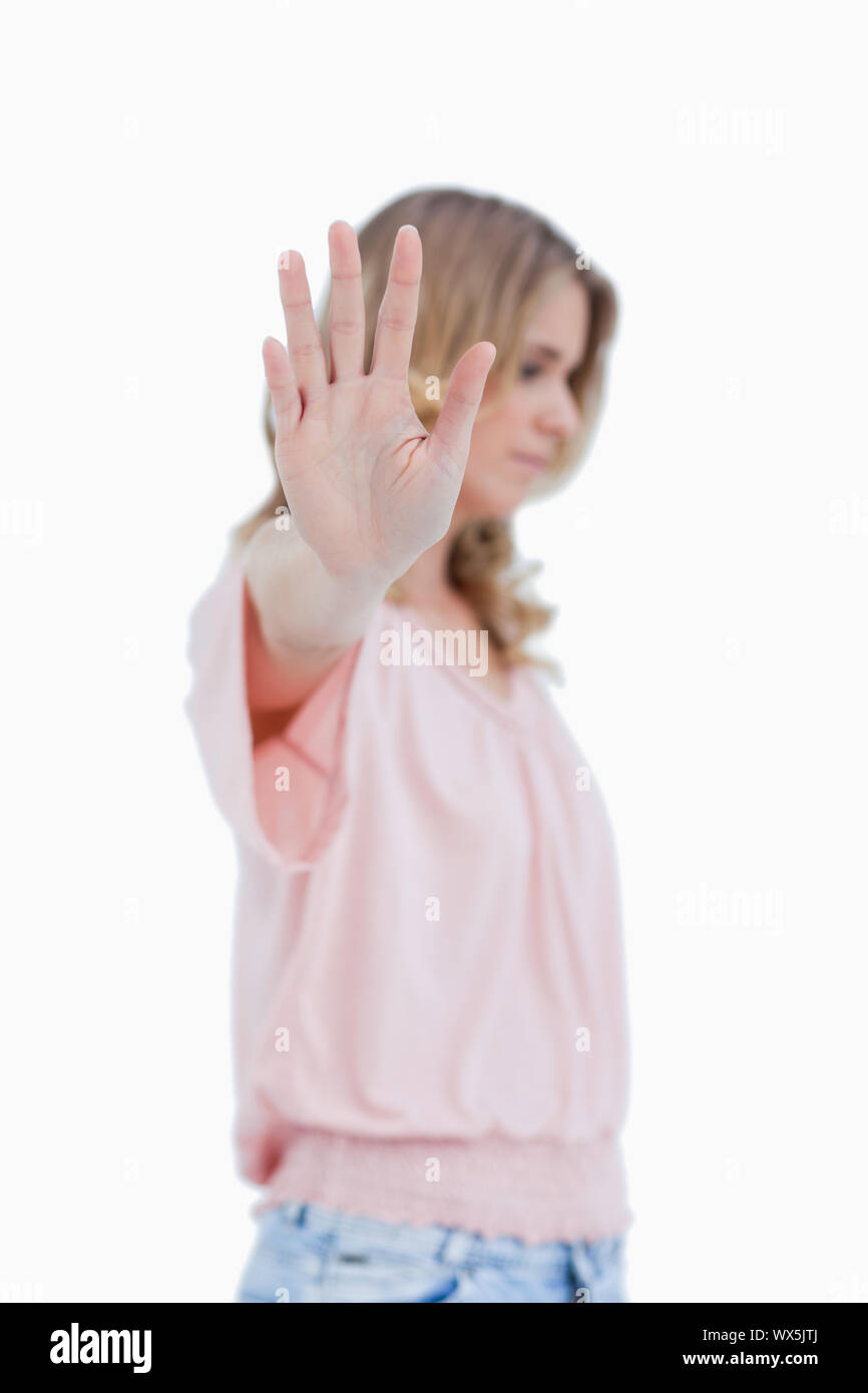 A side view shot of a woman who has her hand held up to the camera ...