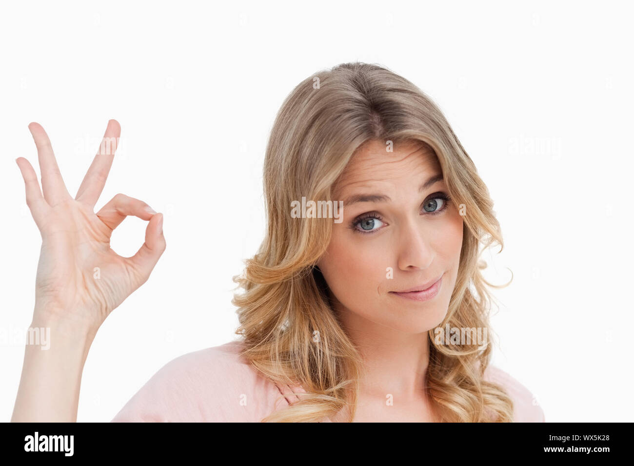 Relaxed young woman showing the ok sign against a white background ...