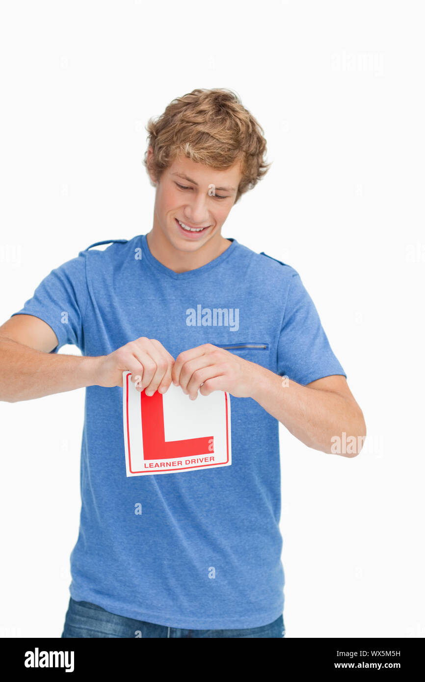 Young man ripping a learner driver sign against white background Stock ...