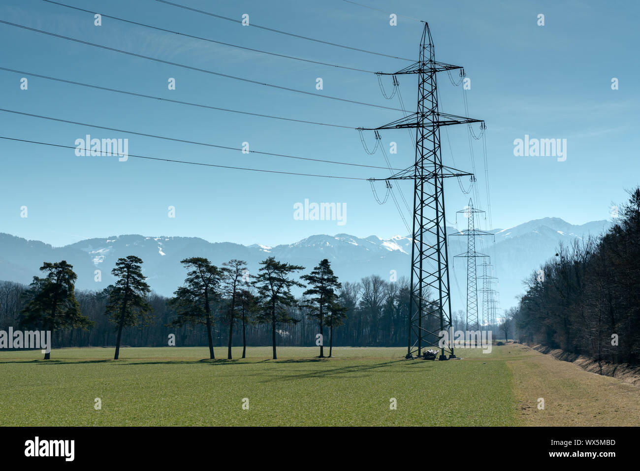 high voltage power lines and tall lattice crosses in rural countryside ...