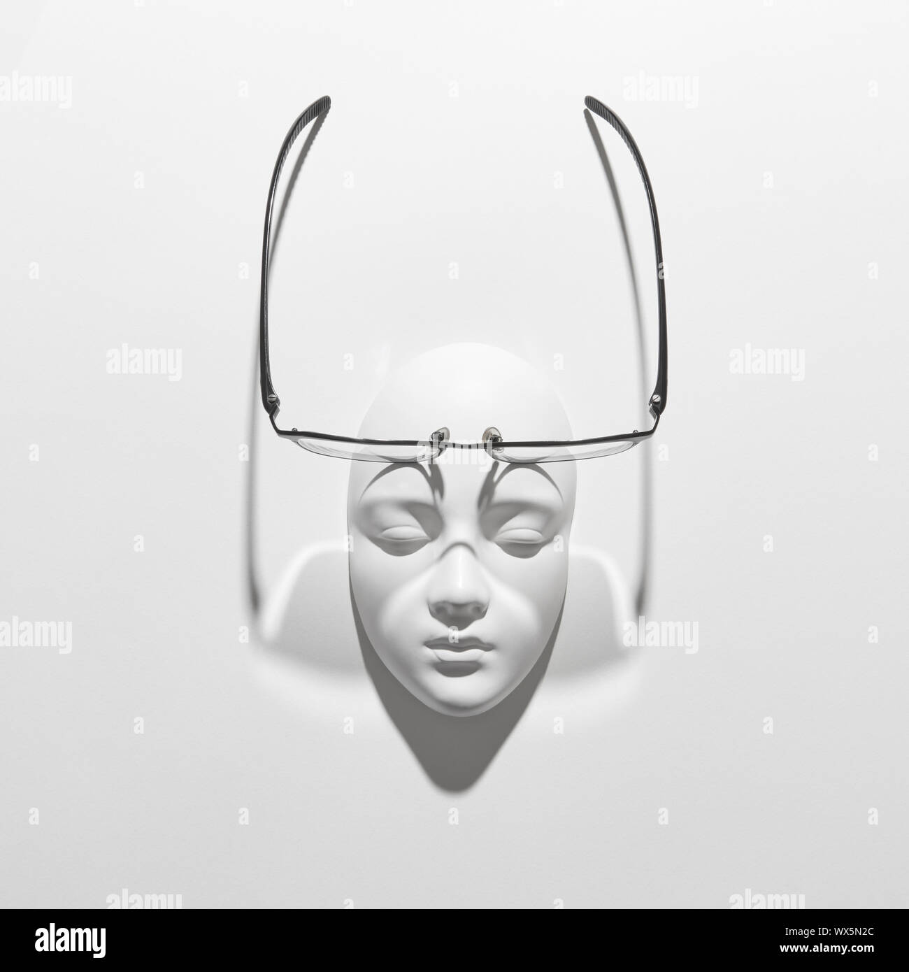 Elegant glasses over white plaster mask on a white background with ...