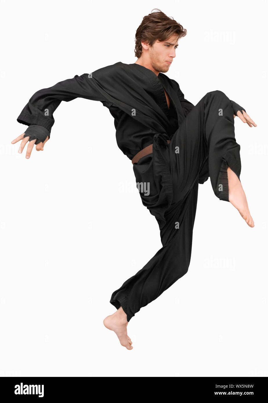 Side view of martial arts fighter attacking with his knee against a ...