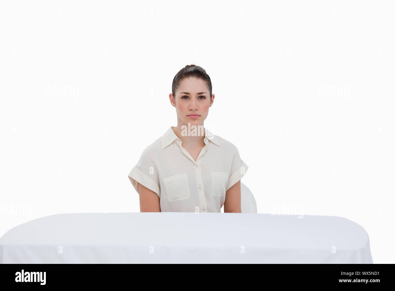 Businesswoman sitting behind a table against a white background Stock ...