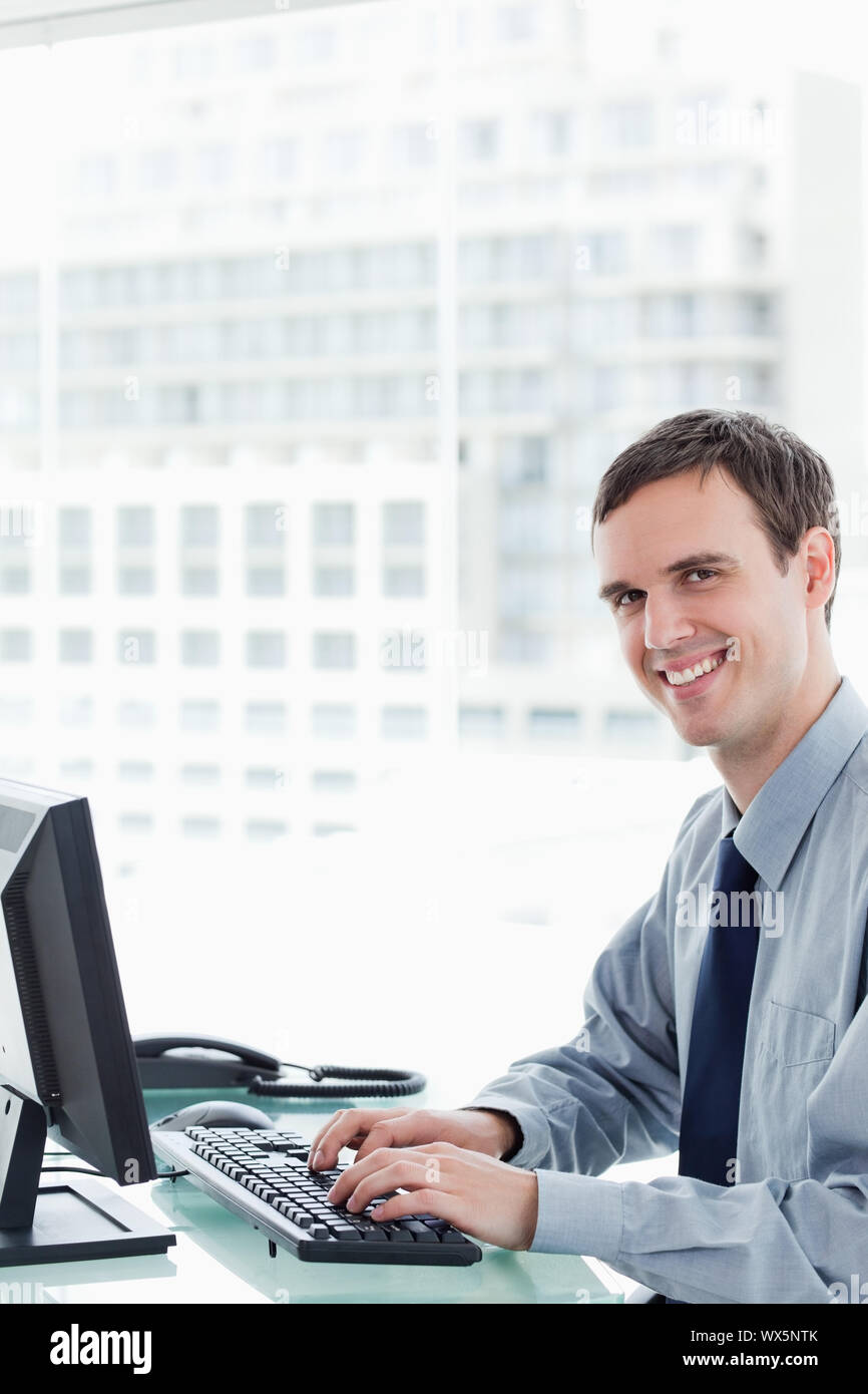 Side view of a happy office worker using a monitor in his office Stock ...