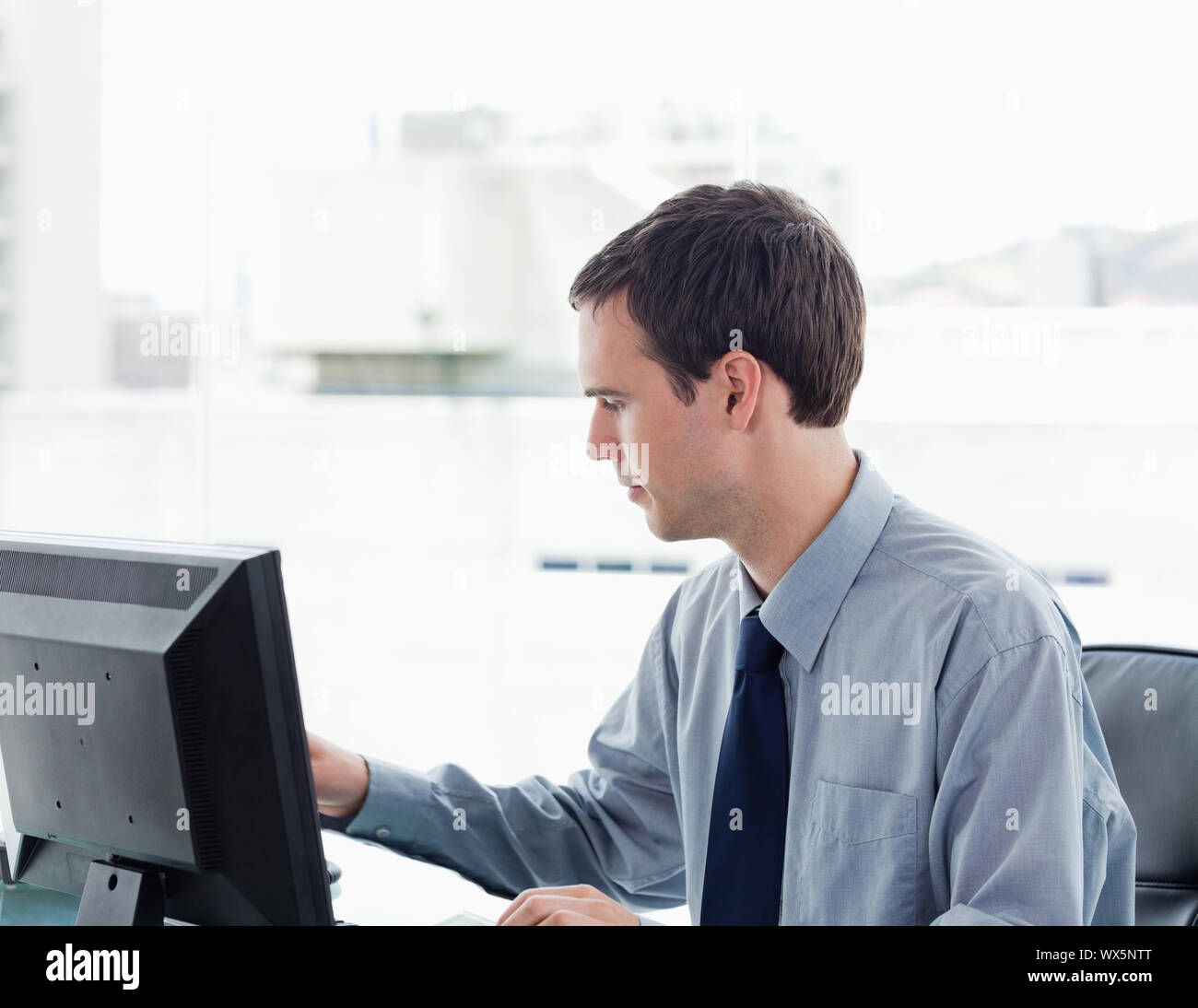 Serious office worker using a monitor in his office Stock Photo - Alamy