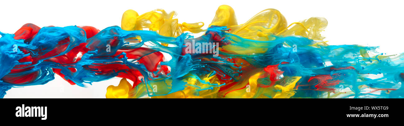 Red, yellow, and blue paints and inks swirling together in water ...