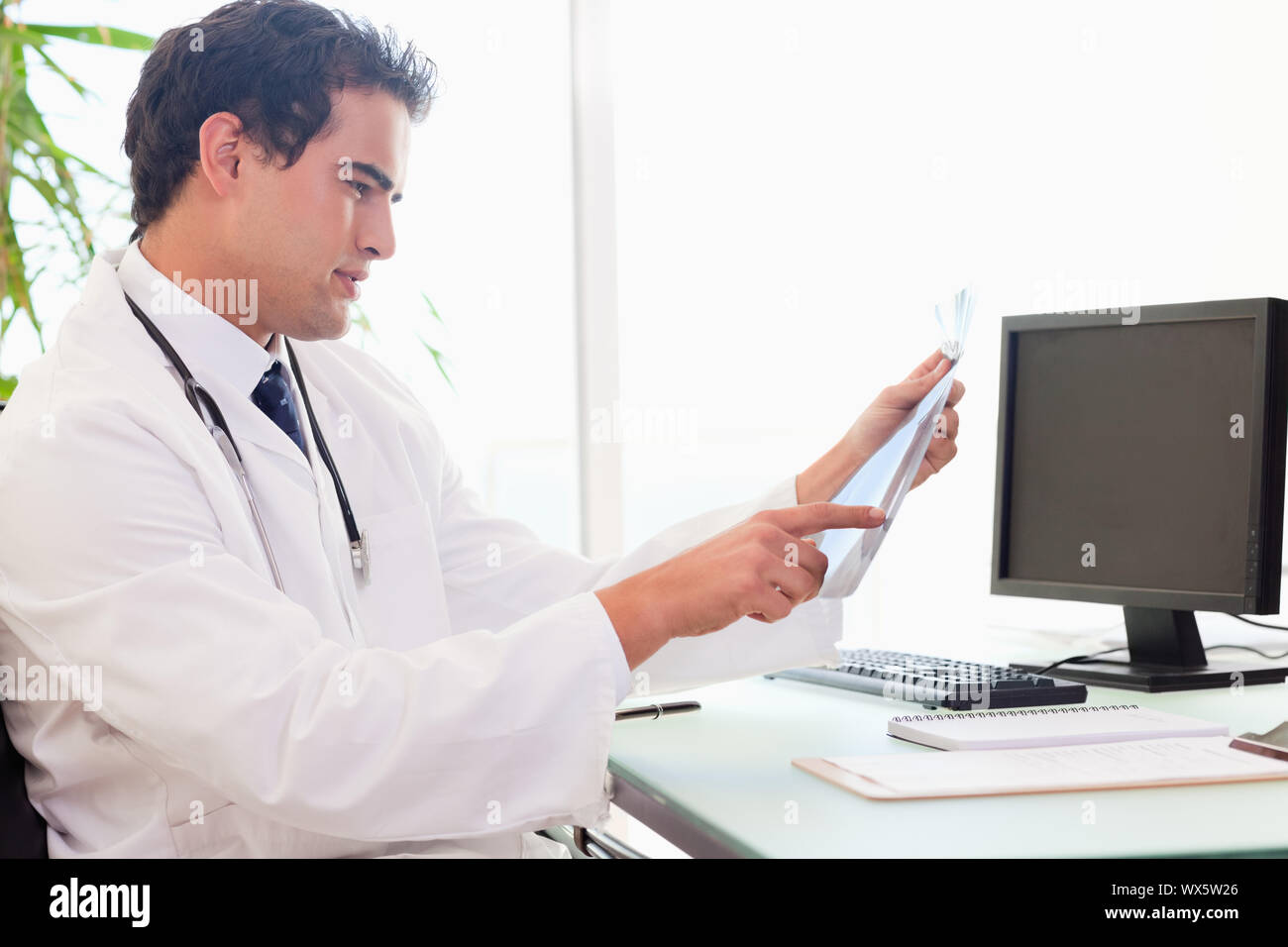 Side view of young doctor with an x-ray at his desk Stock Photo - Alamy