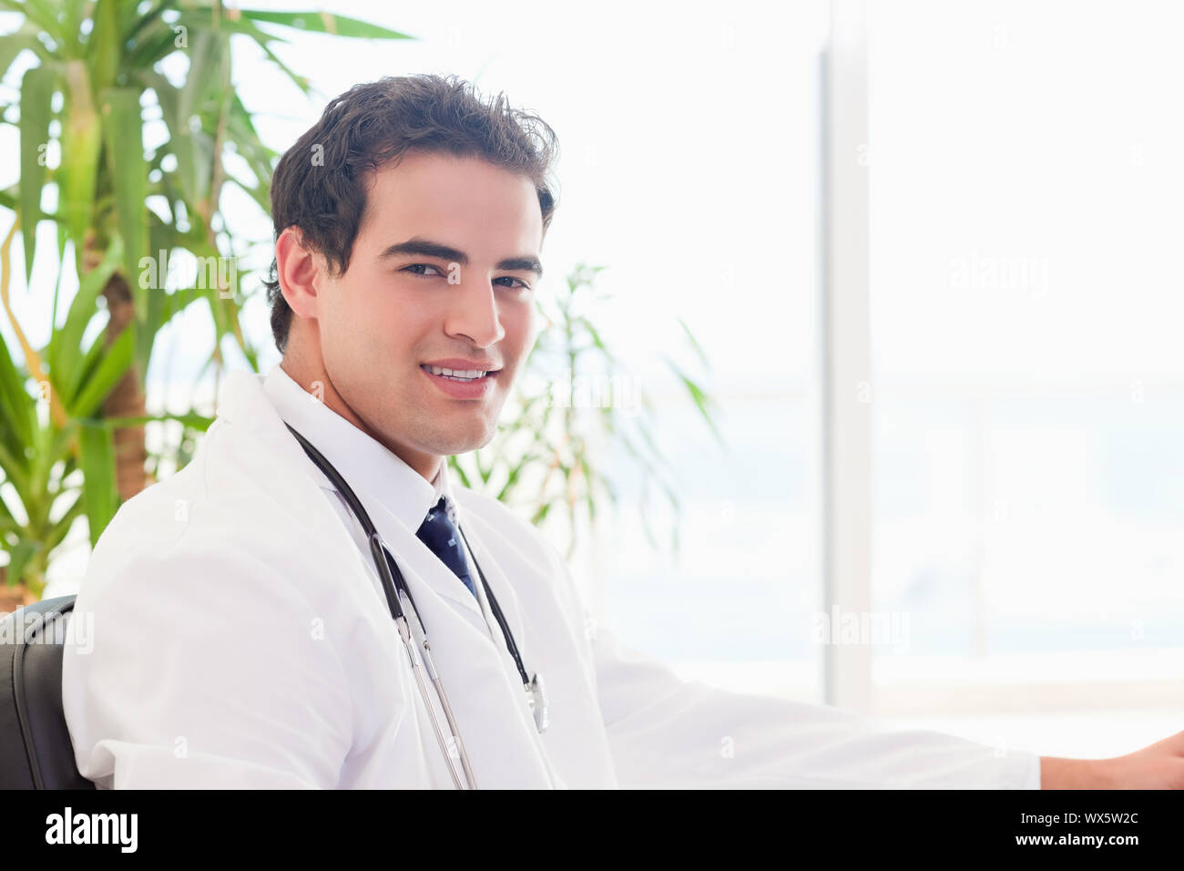 Side view of smiling young doctor Stock Photo - Alamy