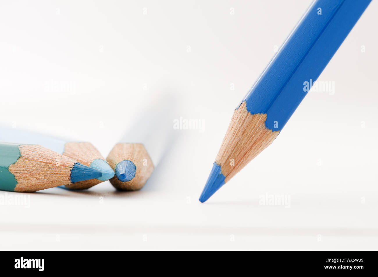 blue colored pencils on paper ground Stock Photo - Alamy