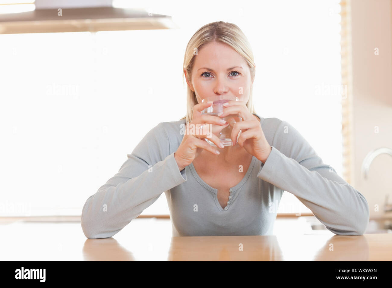 Young woman enjoying a sip of water Stock Photo - Alamy