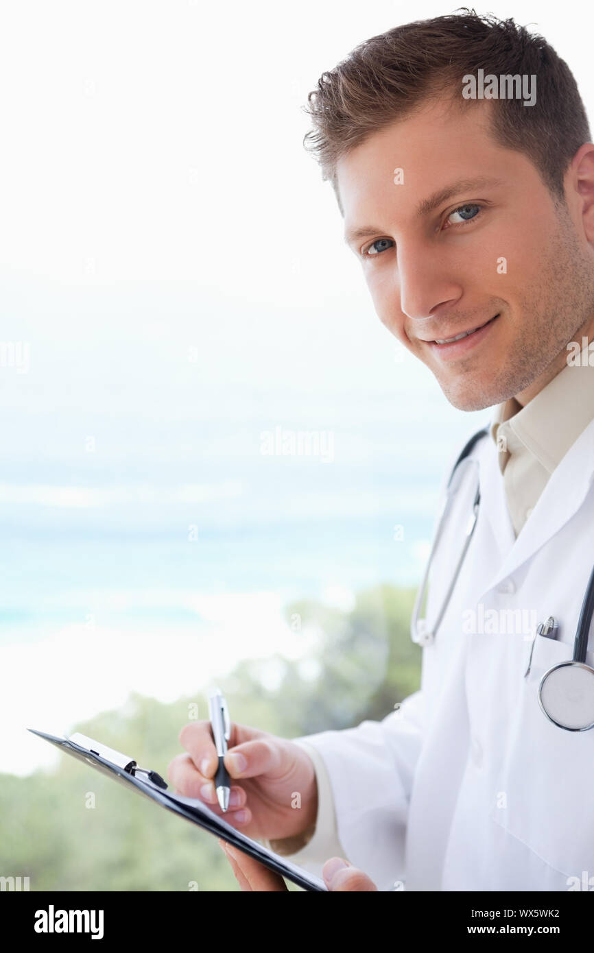 Side view of doctor with pen and clipboard Stock Photo - Alamy