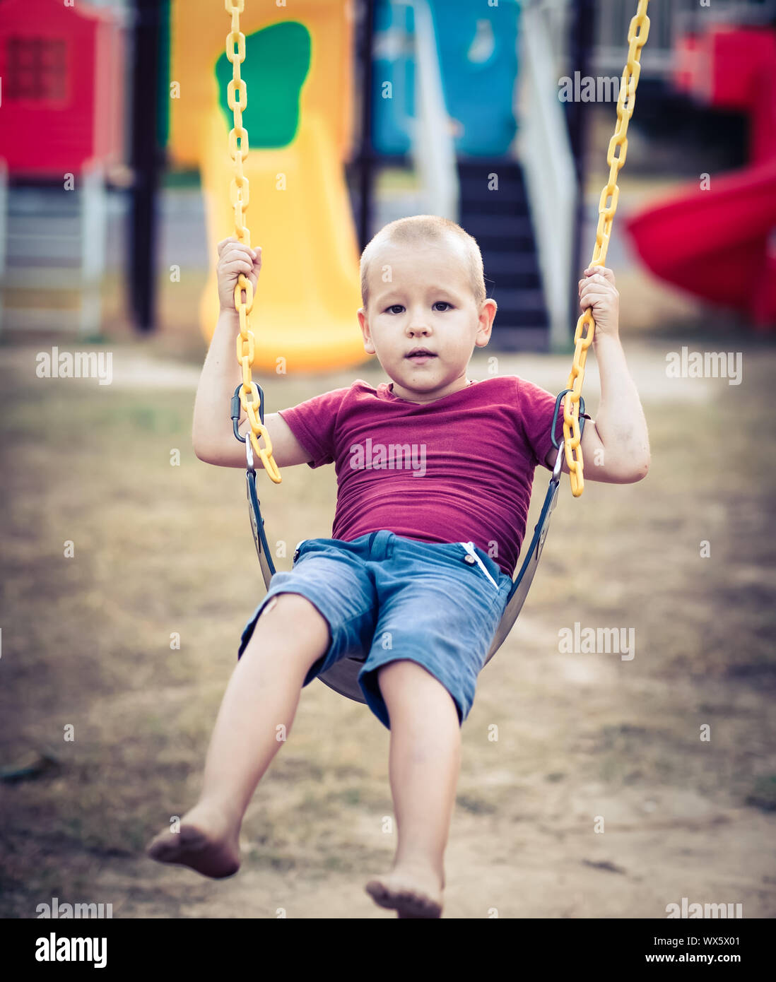 Little boy swinging on a swing Stock Photo - Alamy