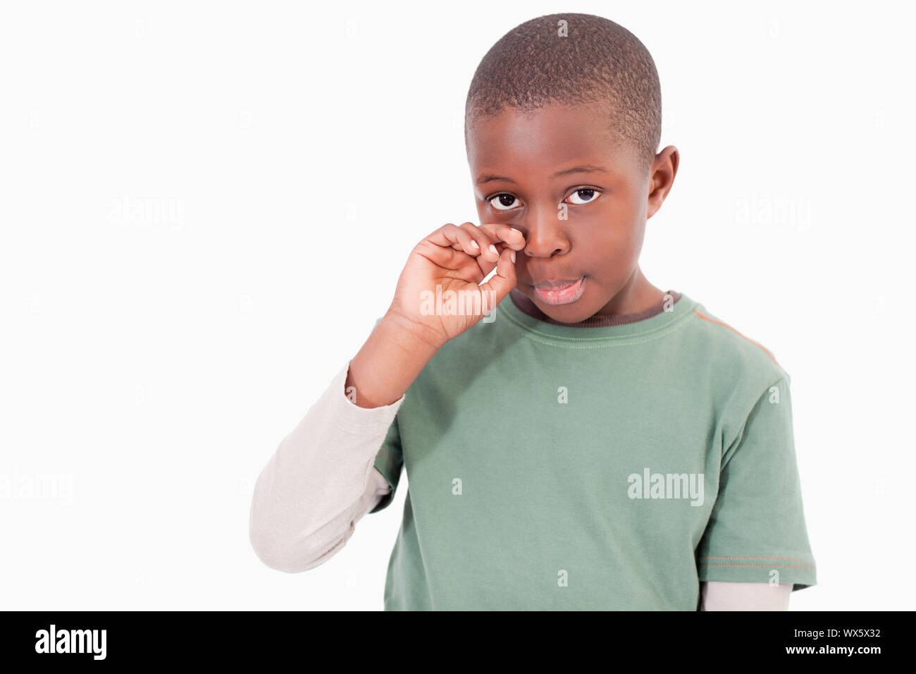 Cute boy crying against a white background Stock Photo - Alamy