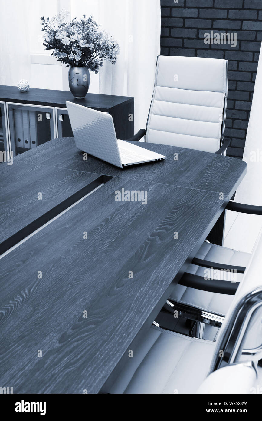 laptop and flowers on desk in modern office Stock Photo - Alamy