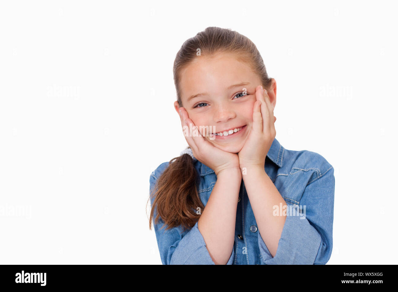 Girl posing with her hands under her chin against a white background ...