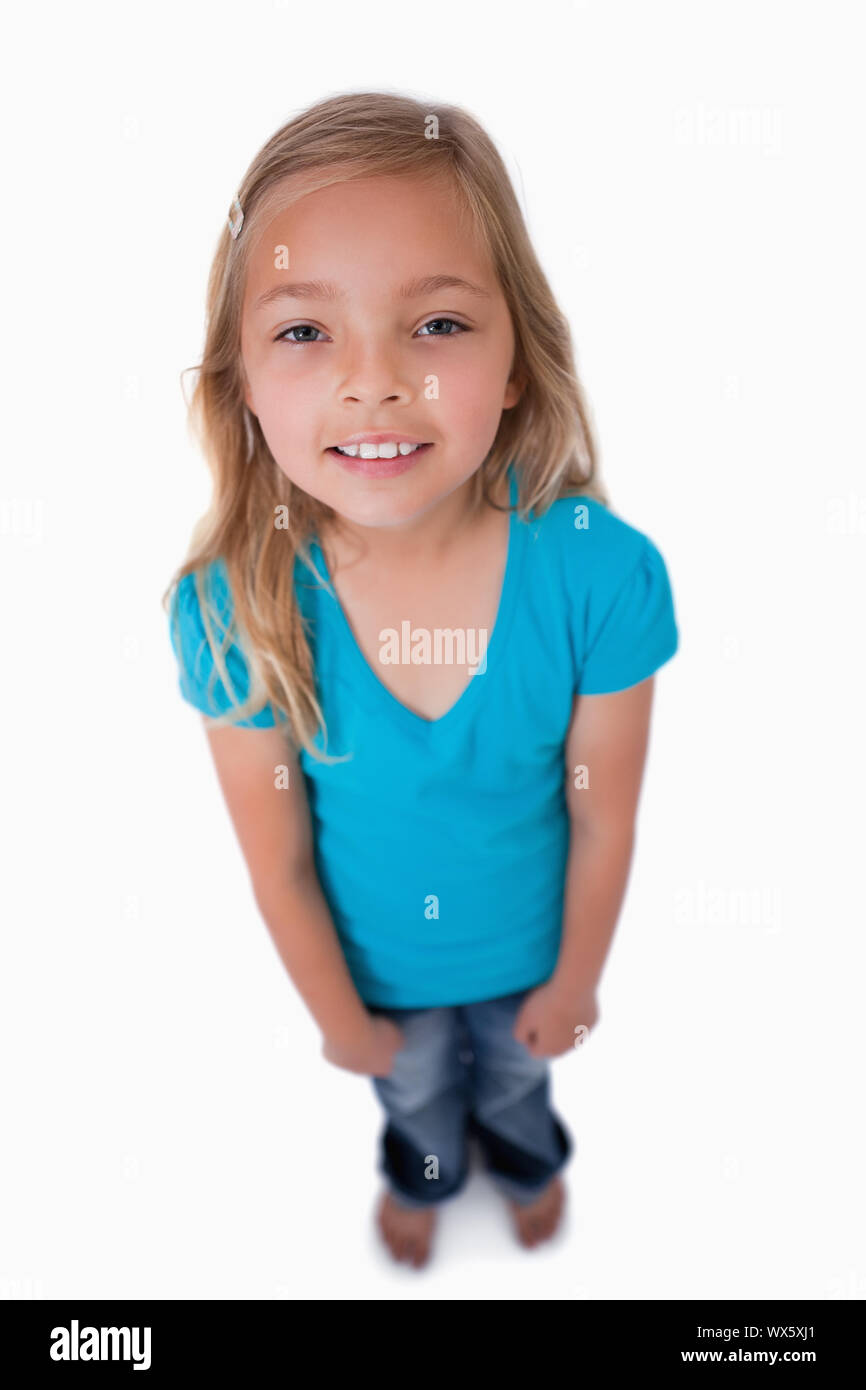 Portrait of a cute girl looking at the camera against a white ...