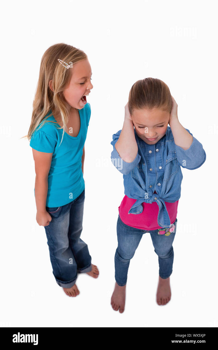Portrait of a girl screaming at her friend against a white background ...