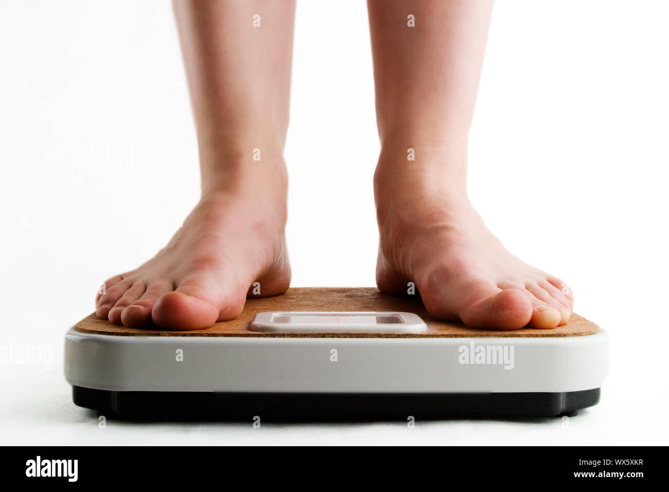 A pair of female feet standing on a bathroom scale Stock Photo - Alamy