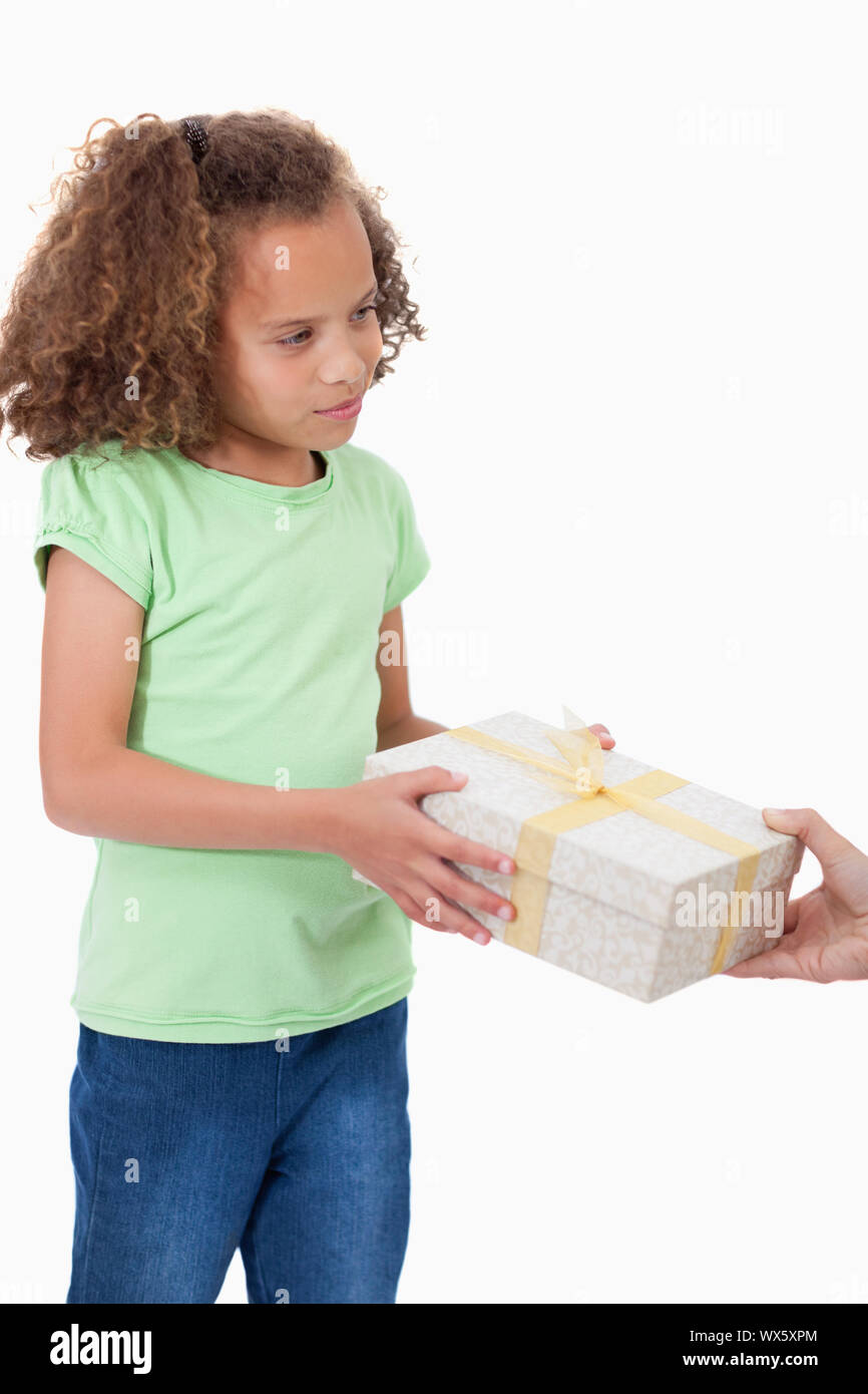 Portrait of a young girl receiving a gift against a white background ...
