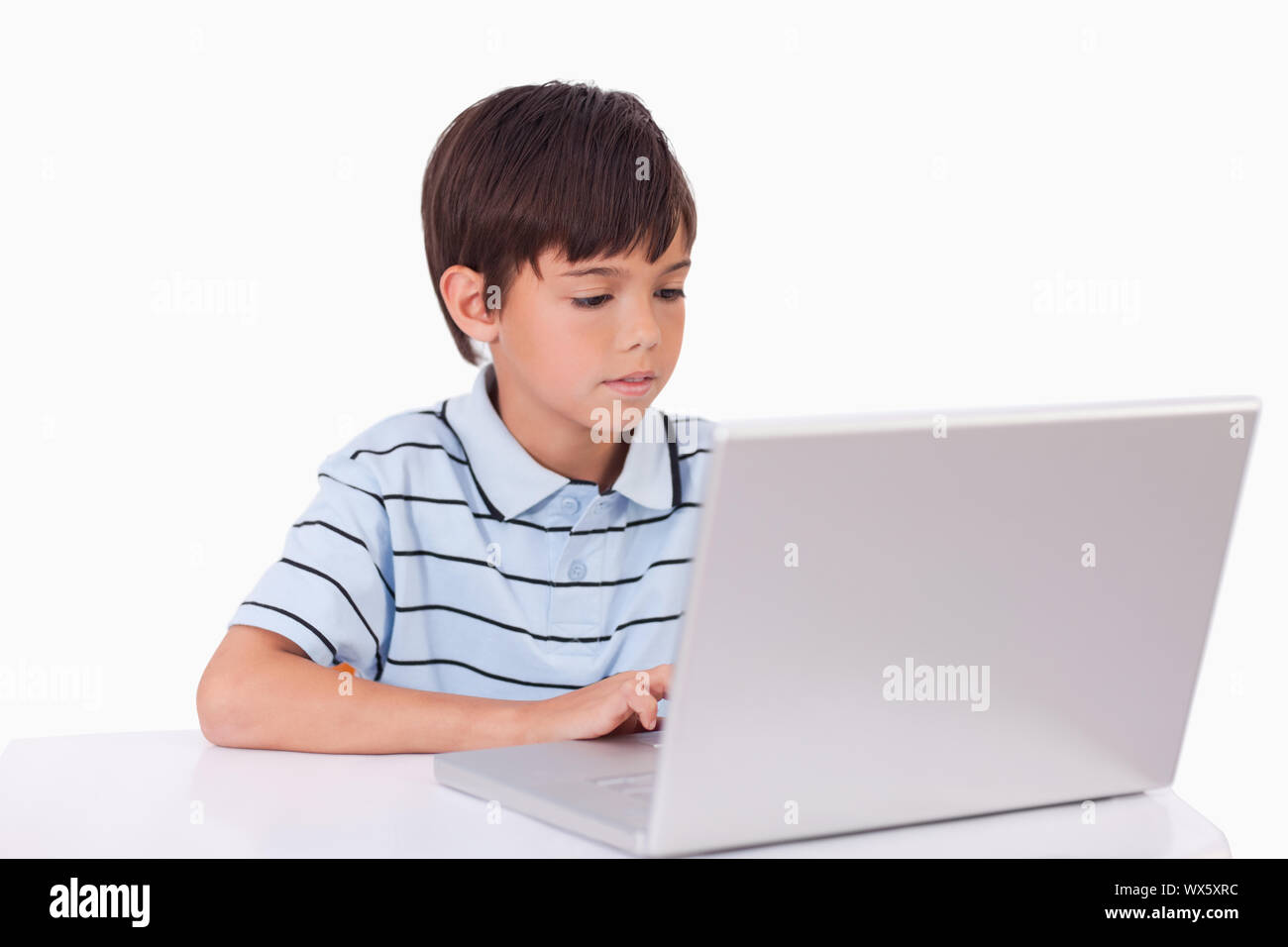 Boy using a laptop against a white background Stock Photo - Alamy