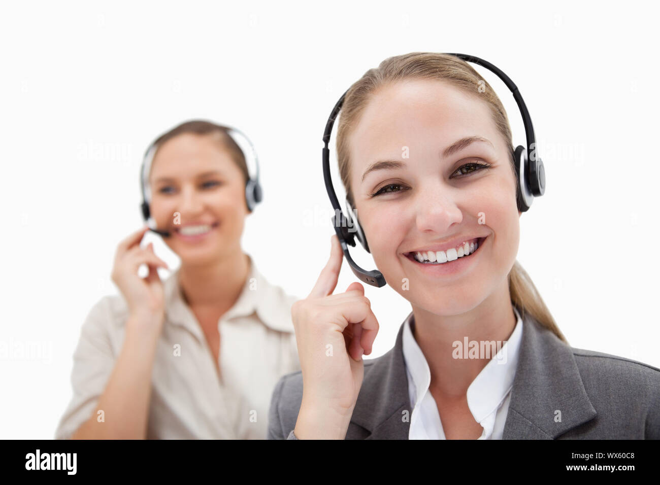 Happy operators using headsets against a white background Stock Photo - Alamy
