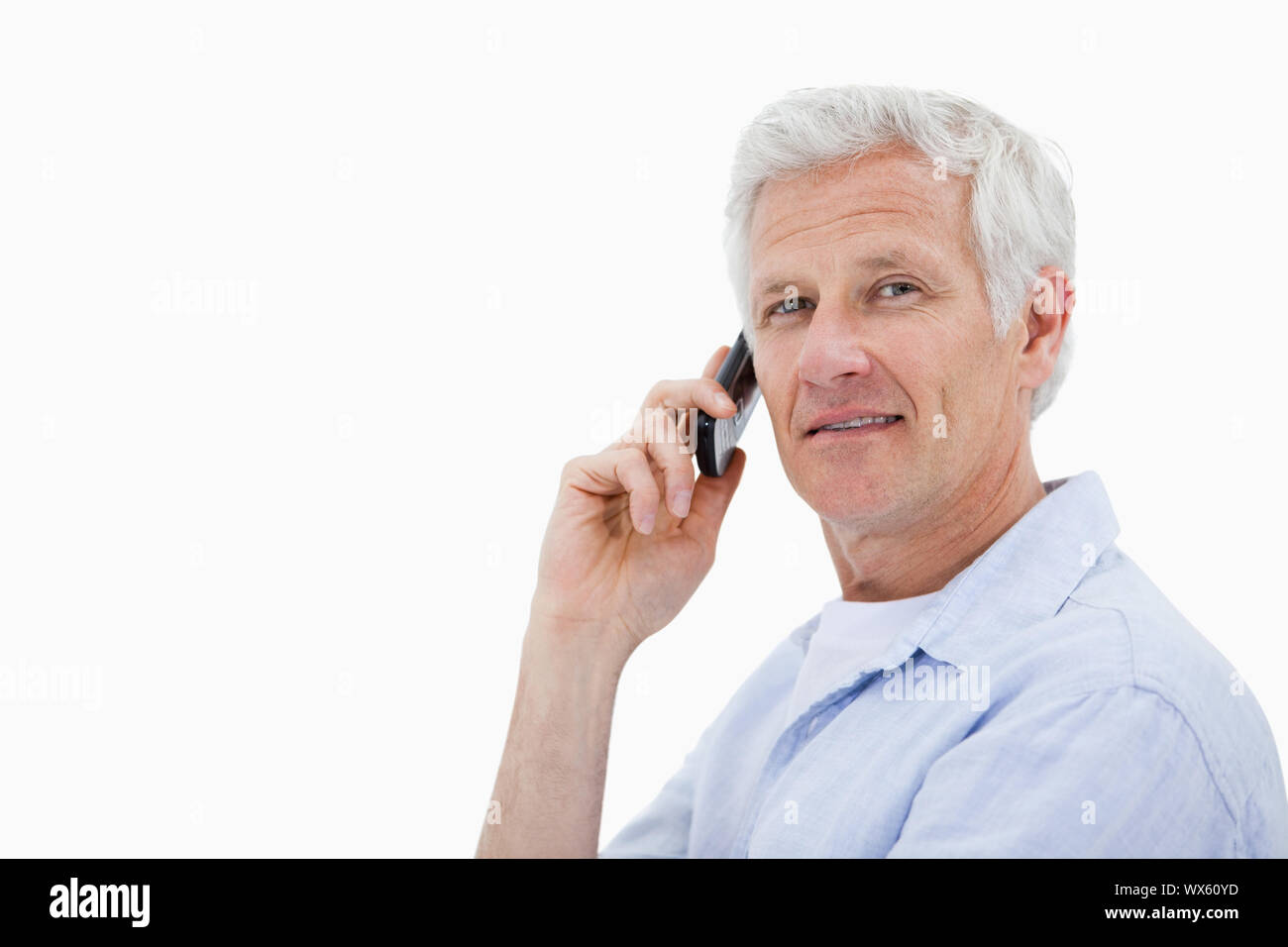 Side view of a man making a phone call while looking at the camera ...