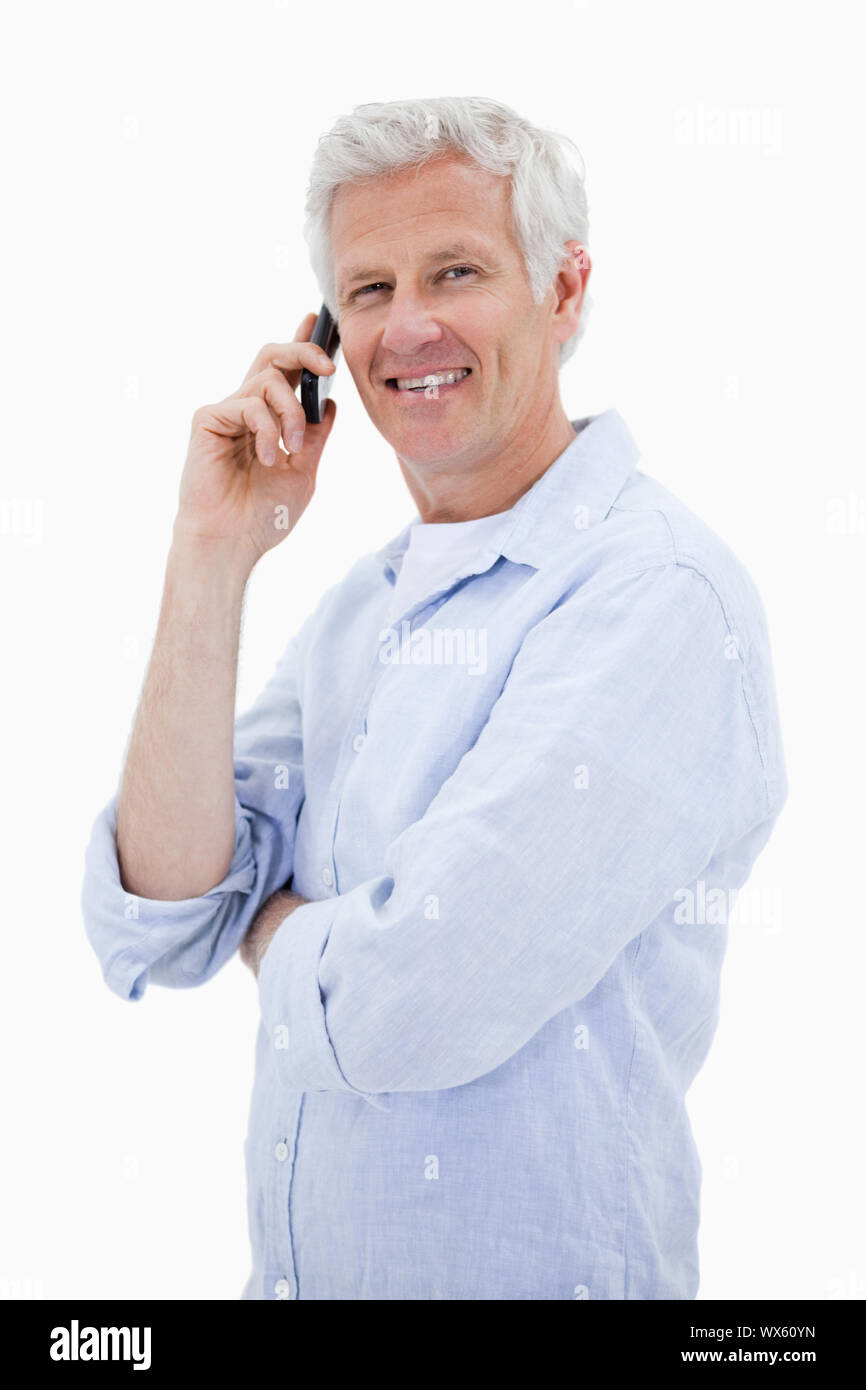 Portrait of a happy man making a phone call while looking at the camera ...