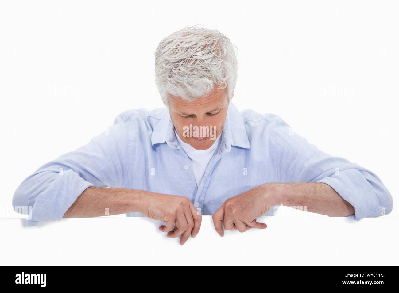 Portrait of a man standing behind blank panel against a white ...