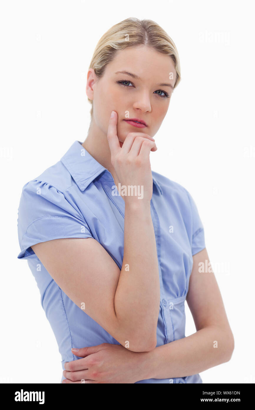 Thinking woman standing against a white background Stock Photo - Alamy