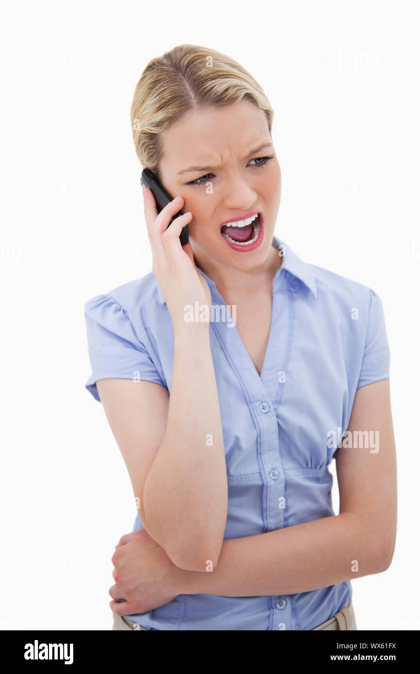 Woman yelling into her phone against a white background Stock Photo - Alamy