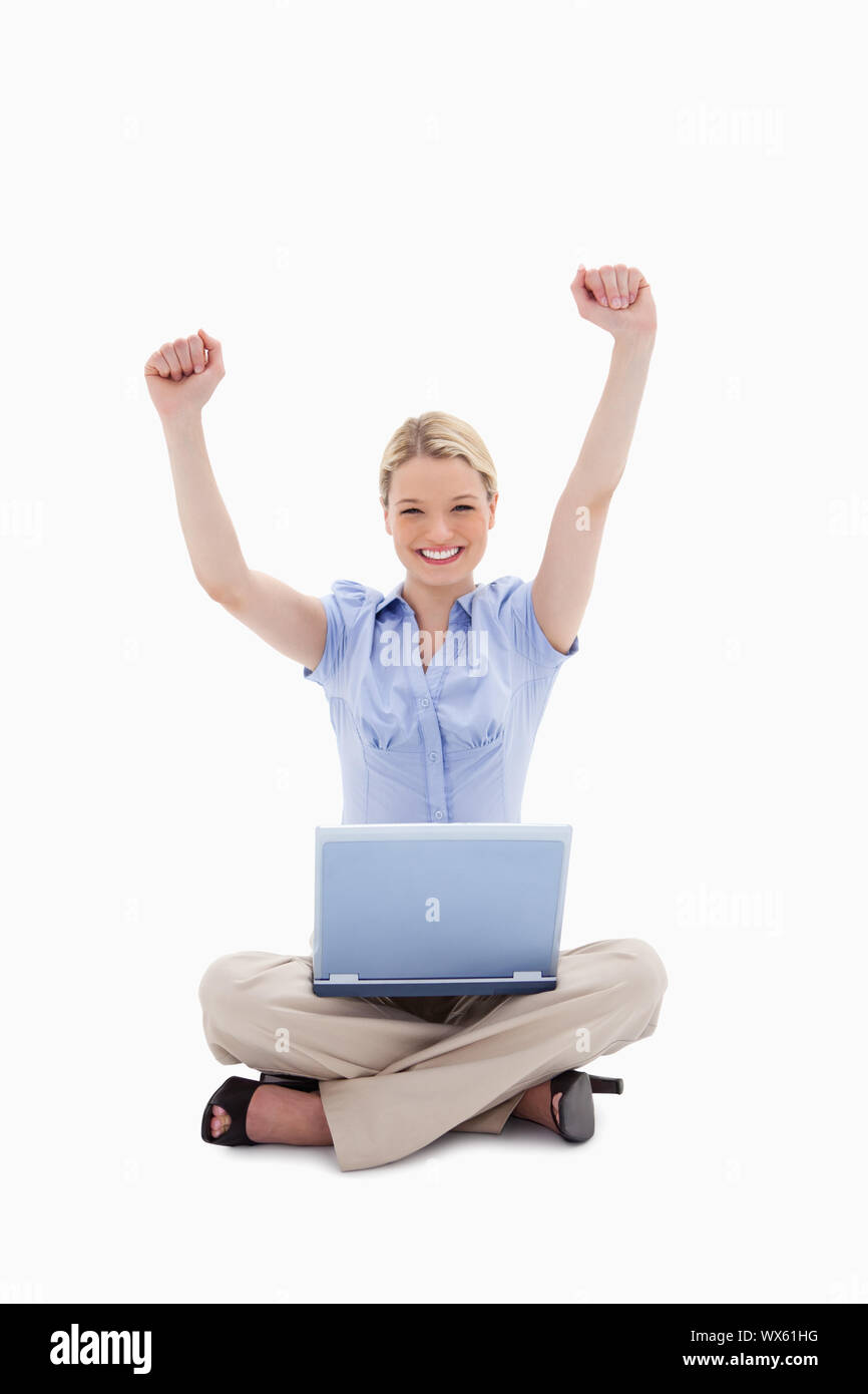 Woman with laptop raising her hands against a white background Stock ...