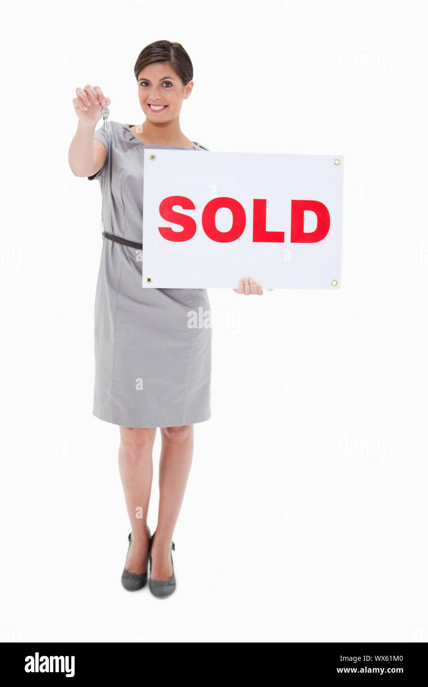 Woman with sold sign handing over key against a white background Stock ...