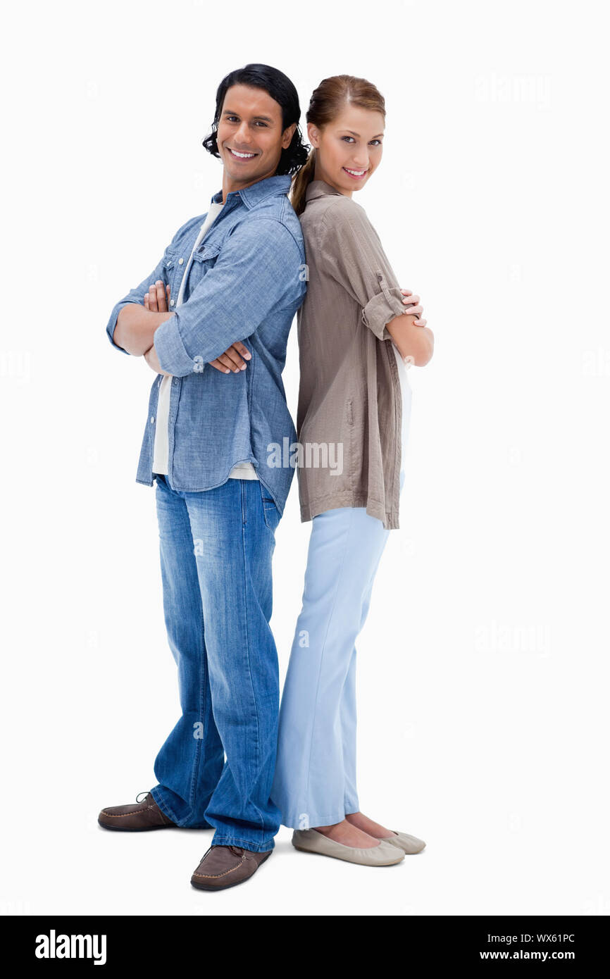 Smiling couple standing back to back against a white background Stock ...