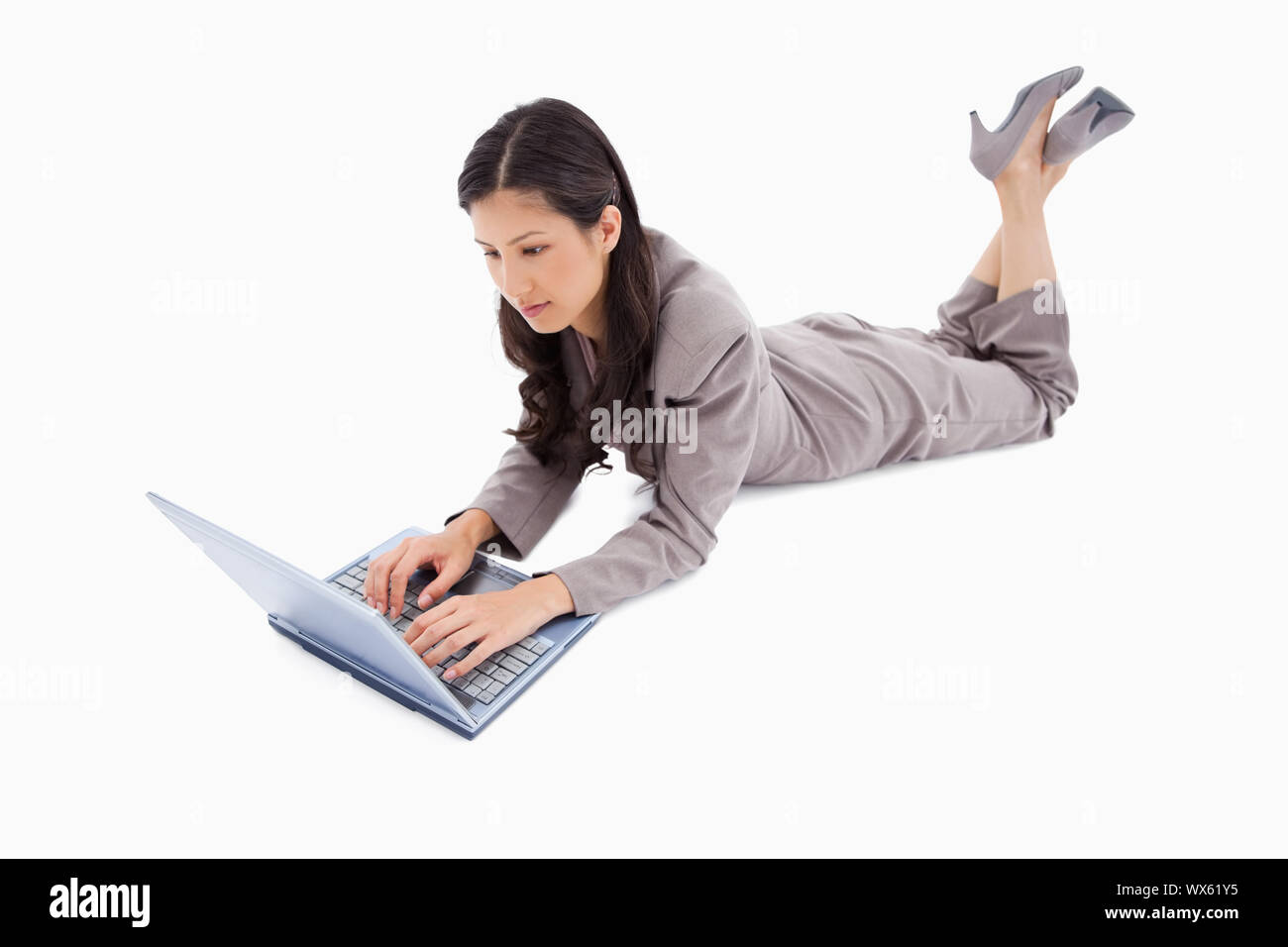 Lying woman working on her laptop against a white background Stock ...