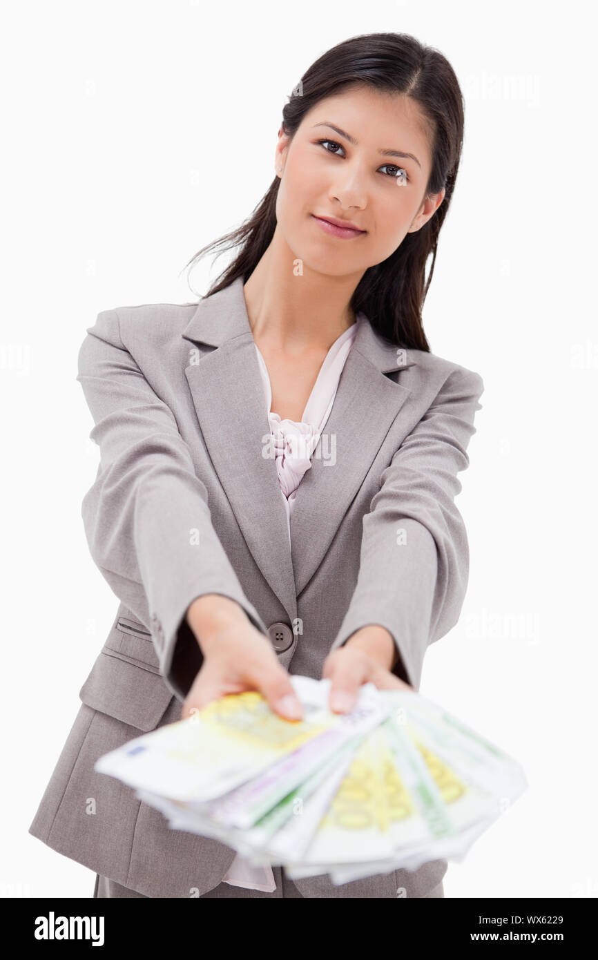 Businesswoman offering money against a white background Stock Photo - Alamy