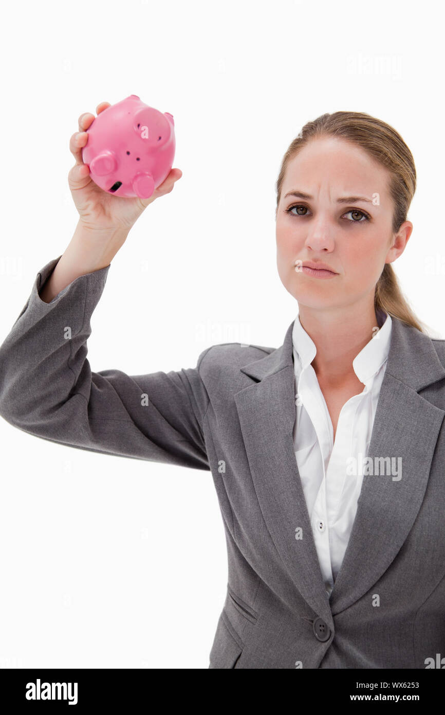 Sad bank employee with empty piggy bank against a white background ...