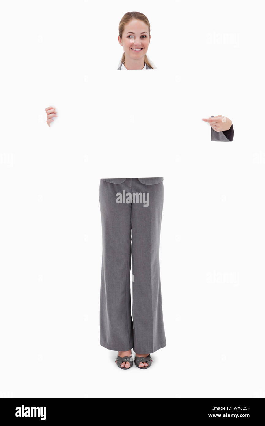 Smiling bank employee holding and pointing at blank sign against a ...