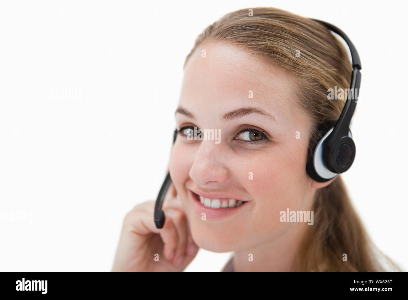 Side view of smiling call center agent with headset against a white ...